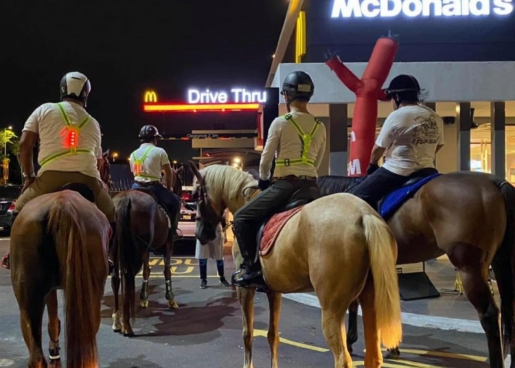 Why are people riding horses through a McDonald's drive-through?